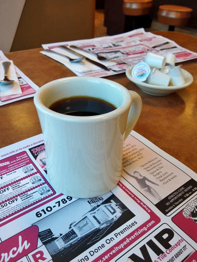 The humble white mug – diner coffee's natural habitat. Nothing fancy, just honest brew that promises to keep your eyelids functioning properly.