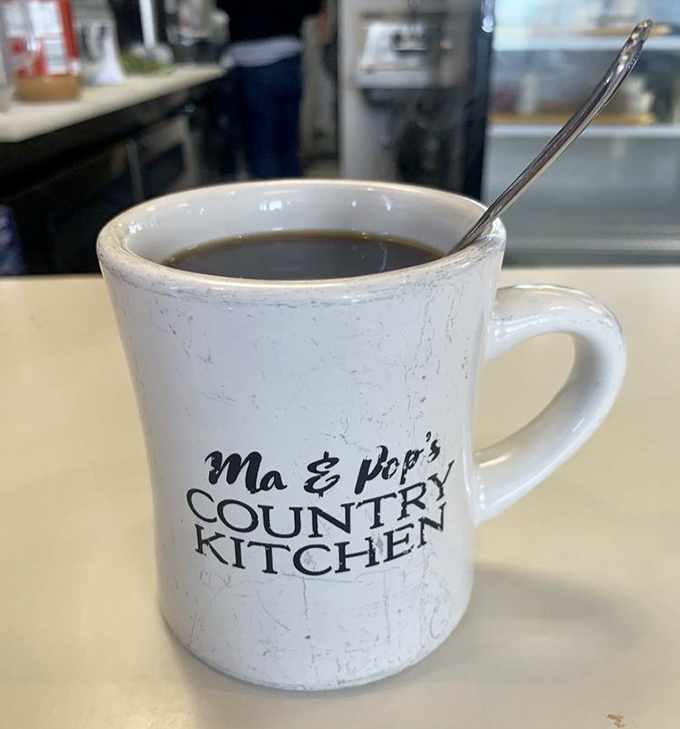 The humble diner mug—battle-scarred veteran of countless refills, proudly bearing the restaurant's name and promising liquid motivation for your day.