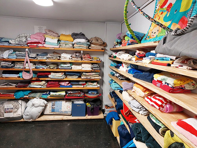 A rainbow of linens and bedding stacked with the precision of a Jenga tower. Someone's future guest bedroom is hiding in these shelves.
