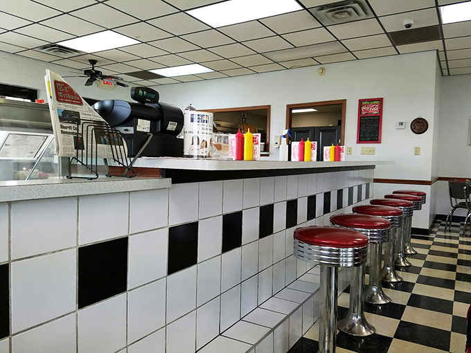 The counter where magic happens – classic black and white tiles supporting red stools that have witnessed generations of first dates and family outings.