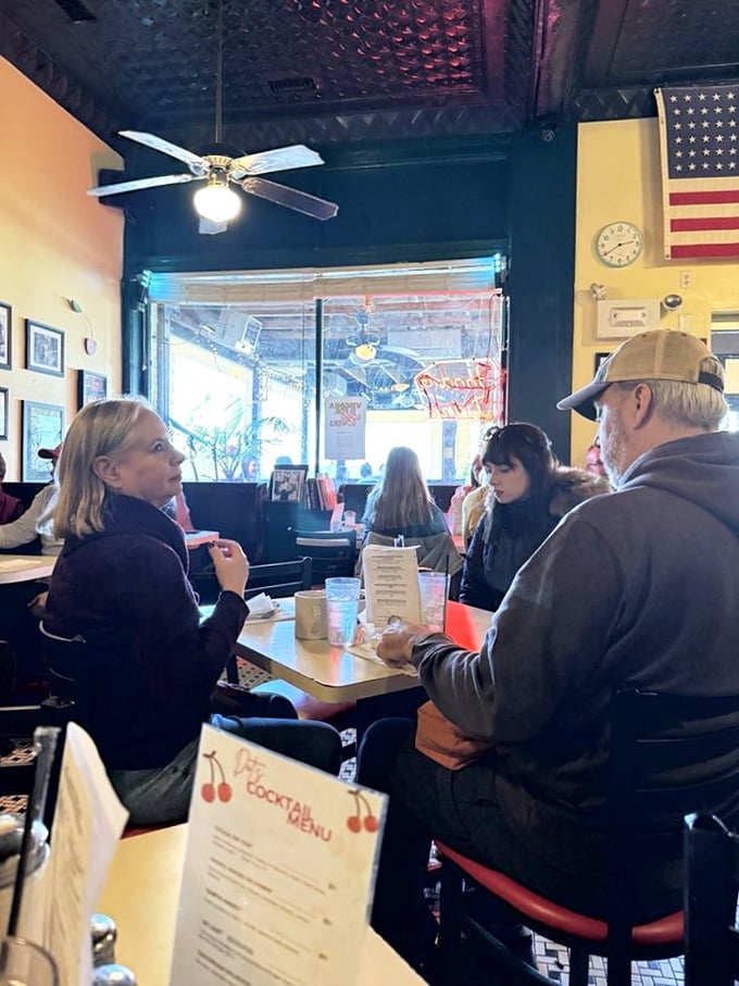 The true heart of Dot's—where neighbors become friends over coffee and comfort food beneath the watchful gaze of an American flag.