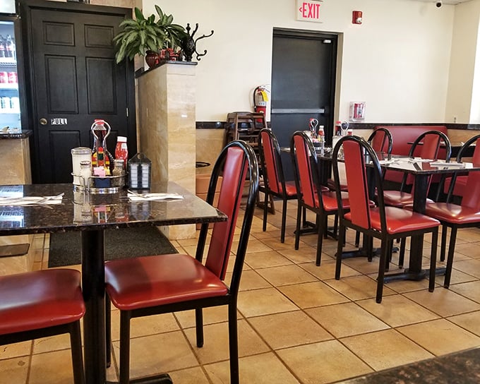 The dining area waits patiently for its next round of hungry patrons. Those red chairs have heard more breakfast debates than any therapist.