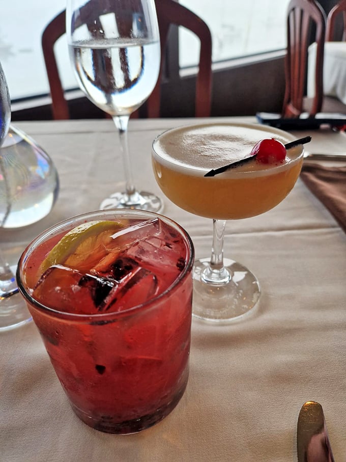 Cocktails that double as liquid artwork—one ruby red with whispers of citrus, one sunset-hued with a cherry crown. Vacation in a glass.