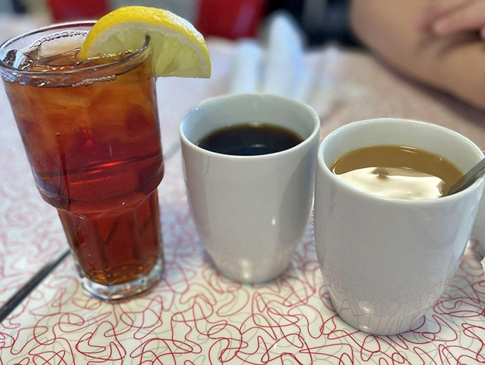 The holy trinity of diner beverages—sweet tea with lemon, coffee black as midnight, and cream-lightened coffee for the indecisive.