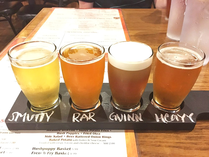 Beer flight perfection – four distinct brews lined up like eager contestants in a delicious beauty pageant for your taste buds.