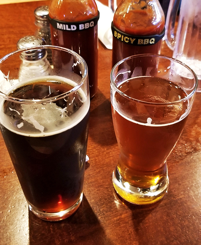 Two beers and house sauces standing by—because proper barbecue hydration is a science and an art form.