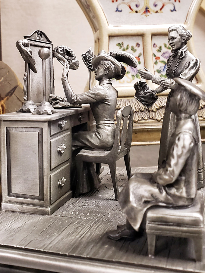 These silver figurines capture a bygone era's elegance, frozen in metal as they prepare for a soirée that never ends.