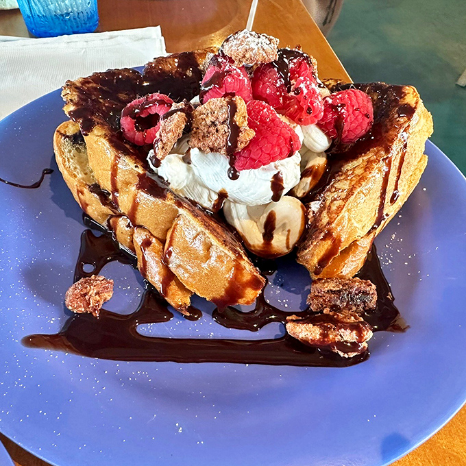 Waffles that have clearly been to finishing school. Those raspberries and chocolate sauce aren't just toppings—they're a morning celebration on a plate.