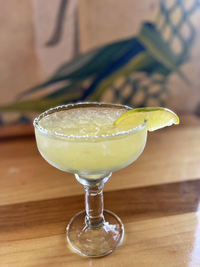 The house margarita arrives like liquid sunshine in a salt-rimmed glass – tart, strong, and refreshing enough to make you forget you're in 110-degree heat.