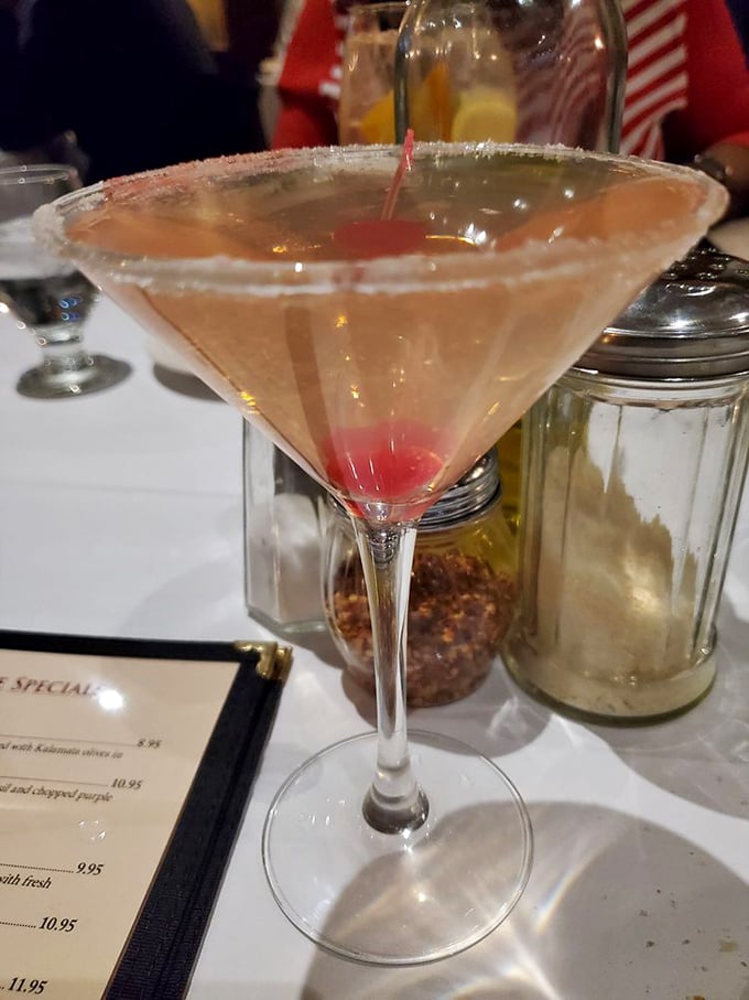 This isn't just a martini—it's liquid elegance with a cherry surprise waiting at the bottom, promising momentary escape from decision-making responsibilities.