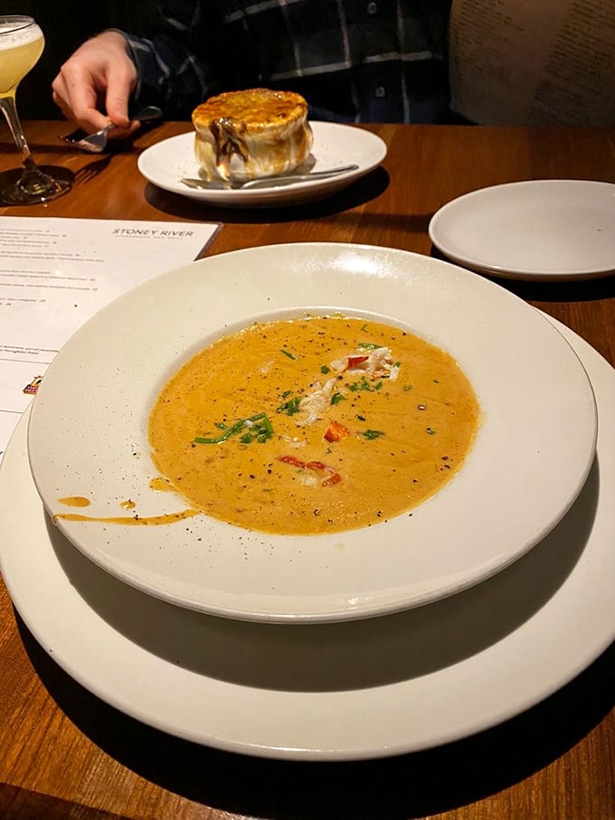 This lobster bisque isn't just soup—it's a velvety orange sea of richness with that pot pie lurking in the background like a delicious photobomber.