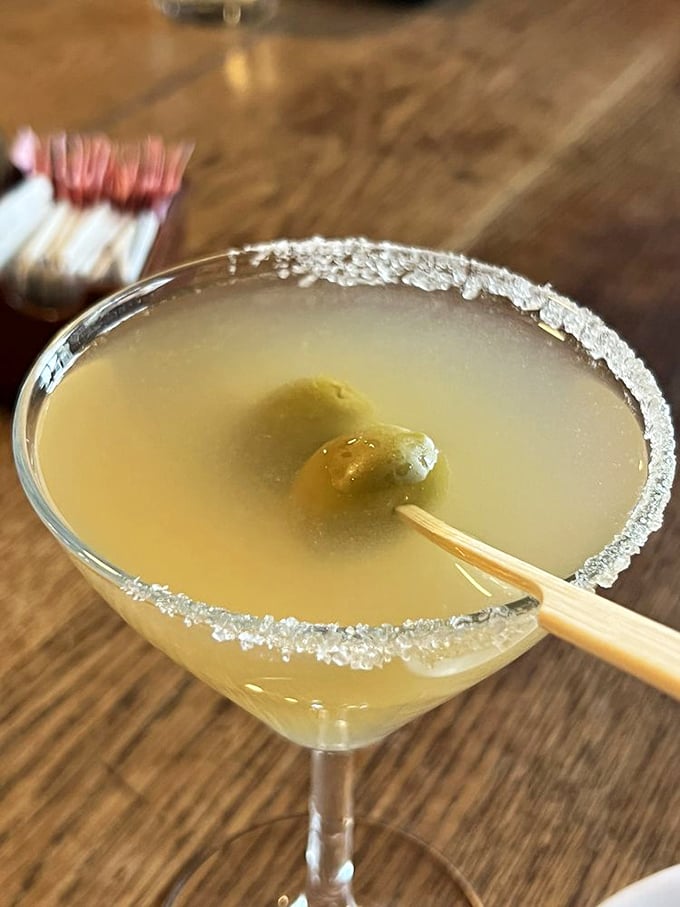 A crystal-clear martini with a salt rim and olive garnish—the civilized way to begin your Texas steakhouse adventure.