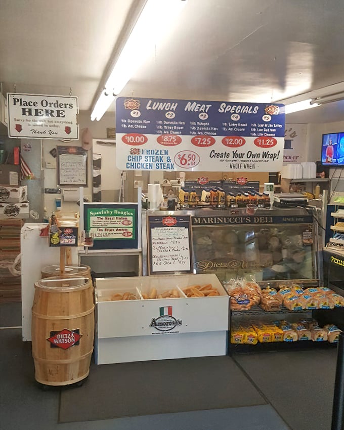 The ordering counter—where sandwich dreams are born and hunger pangs go to die—complete with handwritten specials and barrel displays.