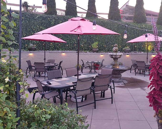 The outdoor patio—where summer evenings, pink umbrellas, and post-dinner conversations create memories that outlast the meal itself.