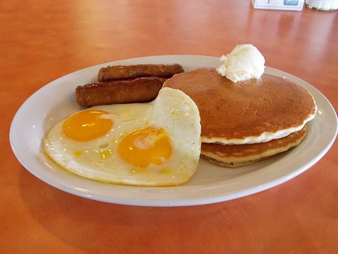 Two perfectly cooked eggs—because even breakfast deserves a little love. Served with golden pancakes and sausage links for a classic morning trio.