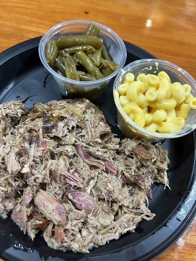 Pulled pork that's been coaxed into tender submission, served alongside mac and cheese that's unapologetically yellow and green beans cooked Southern-style.