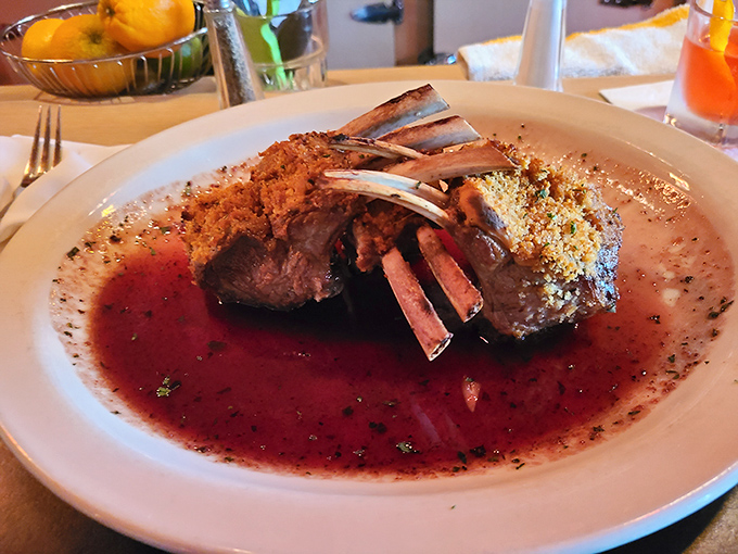 The rack of lamb stands proud like a meaty crown, glistening in its savory reduction. Those exposed bones aren't just for show—they're handles for the civilized carnivore.