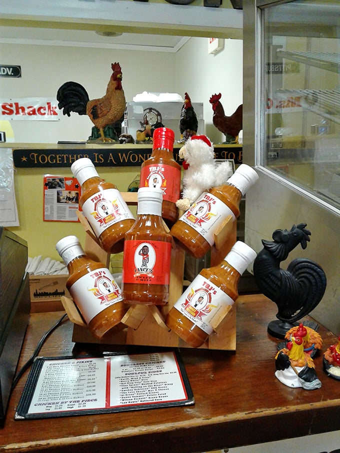 Their signature sauces displayed like liquid treasure, surrounded by chicken figurines standing guard—because flavor this good needs protection.