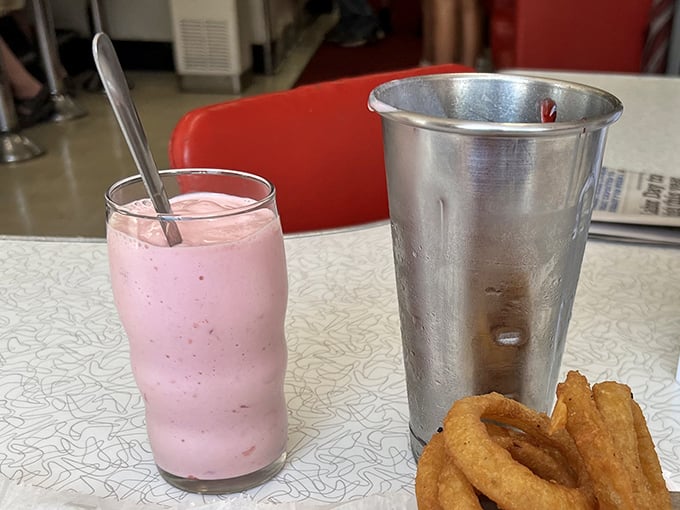 A strawberry shake so thick the straw stands at attention, served with the metal mixing cup – because at K's, leftovers are part of the experience.