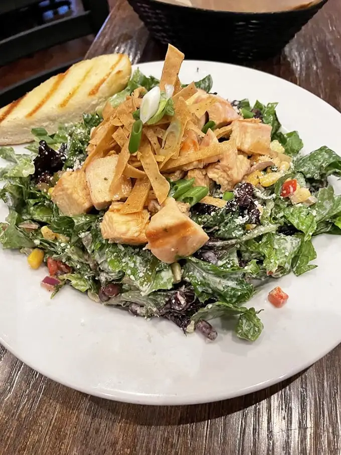 A salad that makes eating greens feel like cheating—where crisp vegetables, tender chicken, and crunchy tortilla strips create the perfect bite.