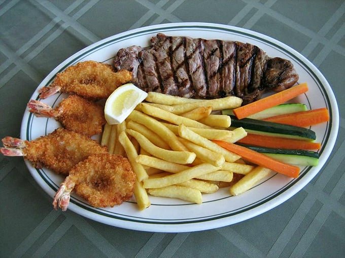 Surf and turf, diner-style—where perfectly grilled steak shares the spotlight with golden-fried shrimp. The vegetables are there to ease your conscience, not to steal the show.
