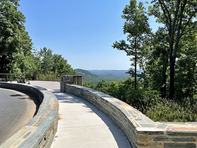 The stone observation deck curves like a smile along the mountainside, offering views that make even smartphone cameras seem inadequate.