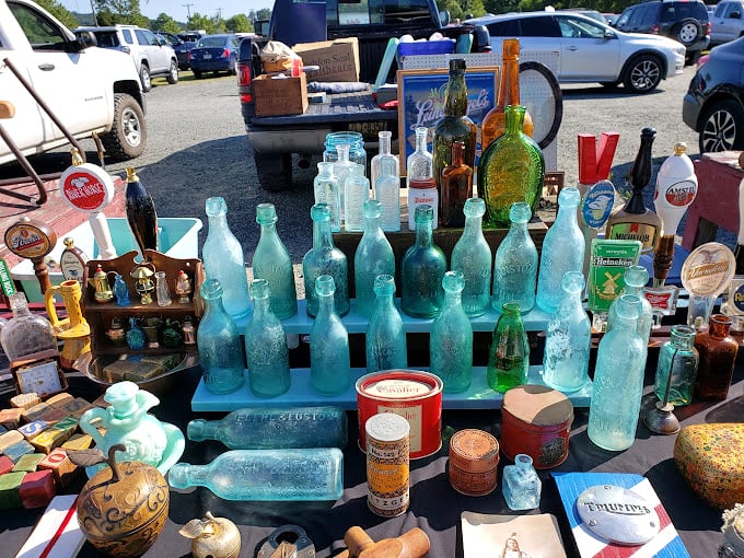 Aqua glass bottles catching the sunlight like jewels – each one carrying stories of sodas, medicines, and spirits from generations past.