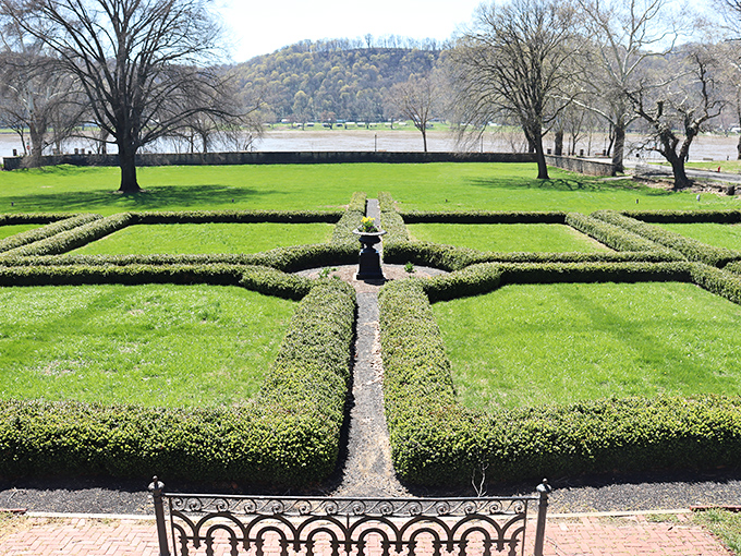The Lanier Mansion's manicured gardens form a living chessboard of greenery, with the Ohio River providing a shimmering backdrop to this historic estate.