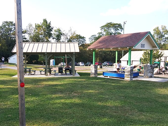 Open spaces designed for gathering, not just passing through—where community happens naturally under simple shelters that serve without pretension.