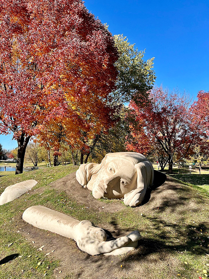 Fall foliage provides a fiery backdrop for the "Awakening Muse," proving that Mother Nature might be the park's most talented artist.