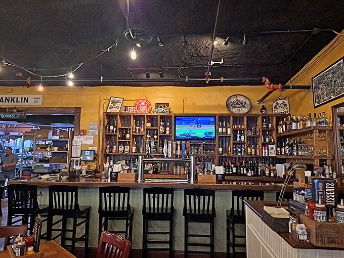 The bar doesn't just serve drinks; it tells stories through bottles and Tennessee spirits, all under the warm glow of vintage lighting.