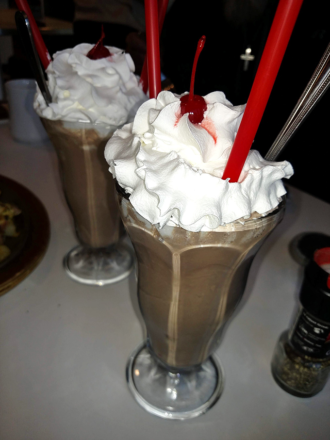 These milkshakes have more whipped cream than my childhood dreams – topped with cherries that say "yes, this is exactly what your day needed."