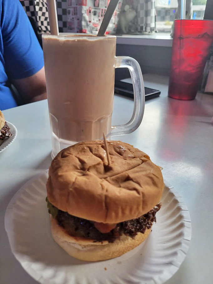 The chocolate malt stands tall beside its burger companion—a partnership more reliable than most Hollywood marriages.