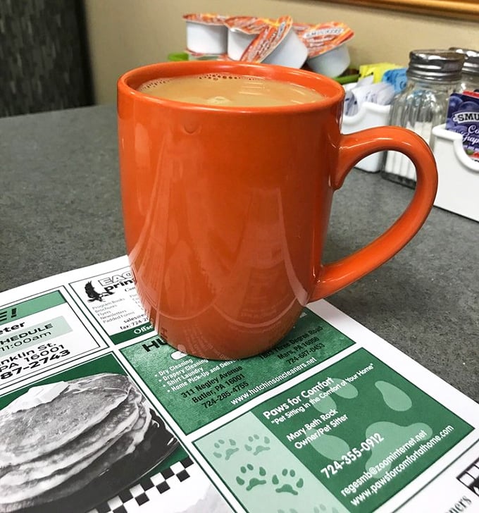 That distinctive orange mug signals serious coffee business – the kind that's refilled before you realize you need it, keeping conversations and days flowing smoothly.