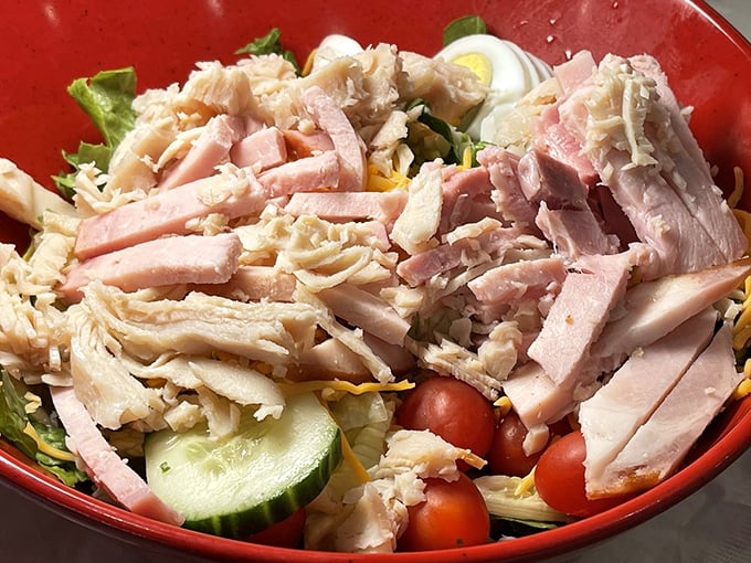 A chef's salad that actually satisfies—protein-packed with generous portions of turkey and ham atop crisp vegetables. No sad desk lunch here!