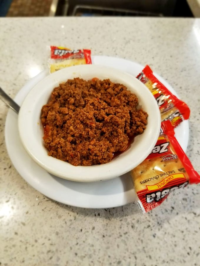 A humble bowl of chili served with crackers—proof that sometimes the simplest pleasures deliver the most profound satisfaction.