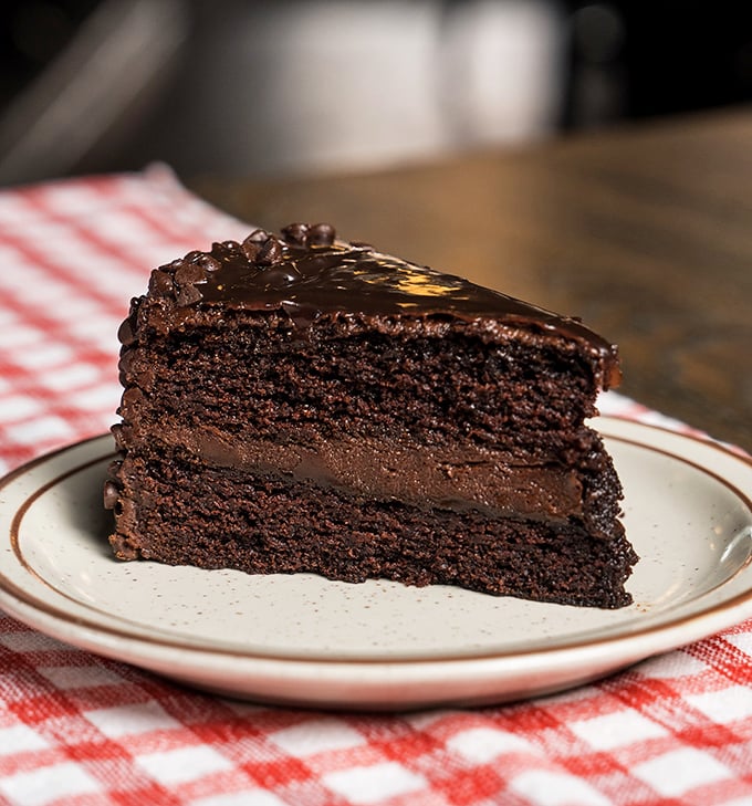 This chocolate cake doesn't need fancy garnishes – three layers of cocoa commitment that would make Willy Wonka reconsider his life choices.