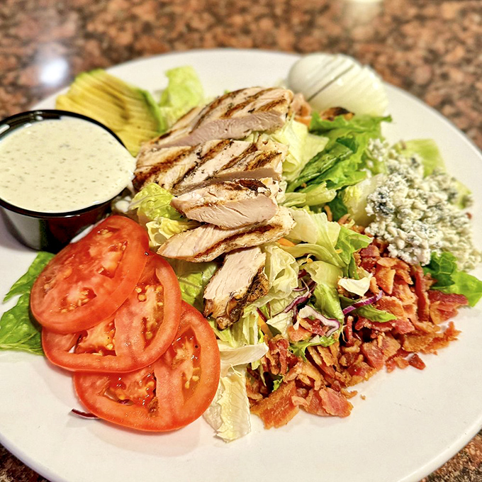This Cobb salad isn't just checking boxes – it's redefining them. Grilled chicken, bacon, blue cheese, and fresh vegetables arranged with artistic precision.