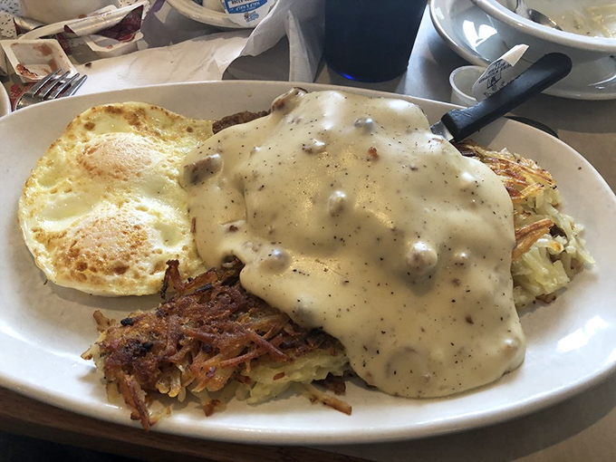 Country fried steak smothered in gravy that cascades like a savory waterfall over crispy breading and tender meat.