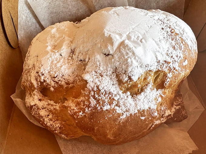 This cream puff isn't just dusted with powdered sugar—it's wearing a snow-capped mountain of it. Inhaling before biting is not recommended.