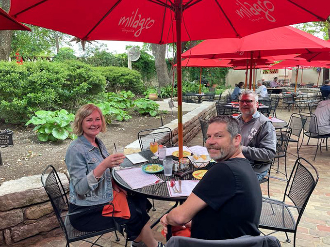 The outdoor patio – where Austinites know the best conversations happen under red umbrellas with margaritas in hand.