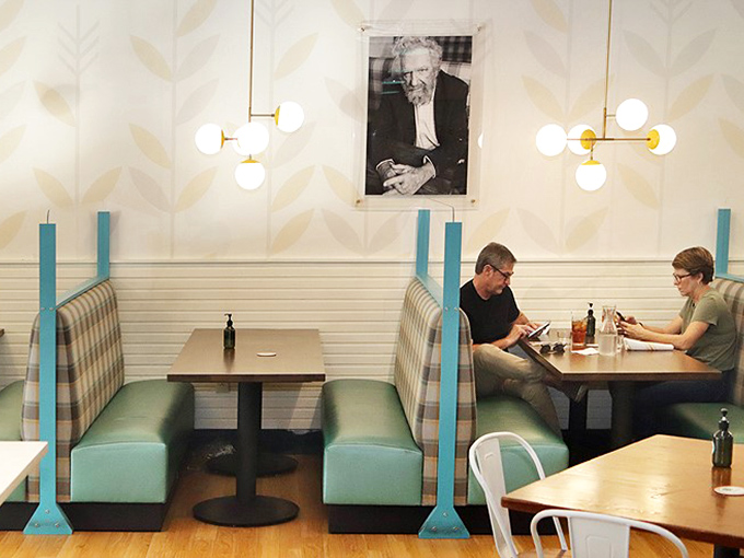 Cozy booths create intimate dining islands where conversations flow as easily as the coffee refills.
