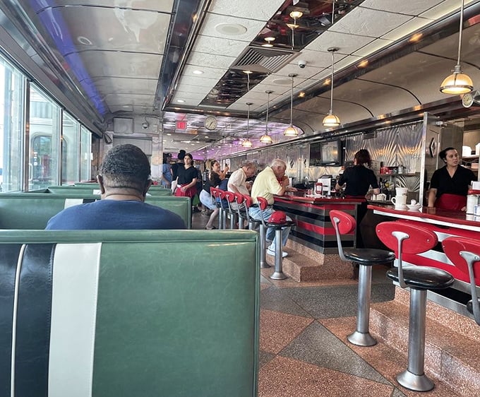 The counter seats—where solo diners become regulars and servers remember your order before you've fully settled onto your stool.