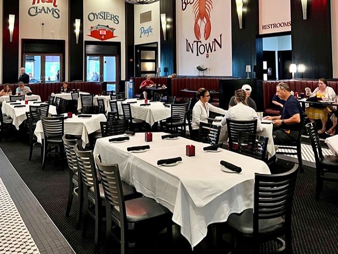 Crisp white tablecloths against dark wood create that "special occasion" feeling. The "Best Lobster in Town" sign isn't bragging if it's true.