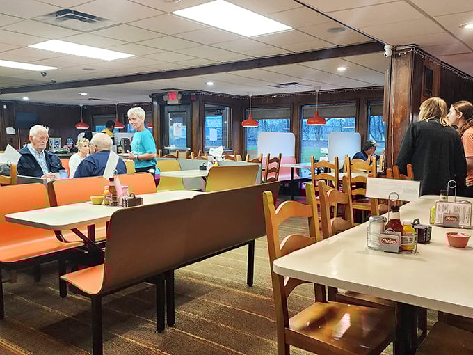 The dining room where strangers become neighbors, tables hold decades of conversations, and red pendant lights cast a warm glow over comfort food central.