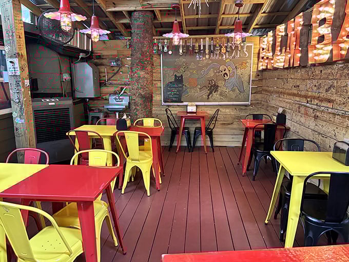 Vibrant red and yellow metal chairs pop against rustic wooden walls. Even the furniture here has personality to spare.