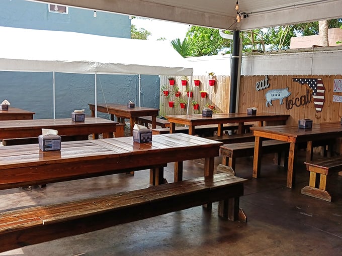 Simple wooden picnic tables under a covered patio create that essential barbecue atmosphere: casual, communal, and ready for serious eating.
