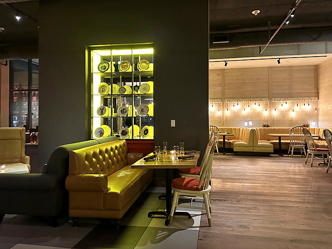 The dining area whispers "stay awhile" with its mustard banquettes and glowing display case—comfort wrapped in urban sophistication.
