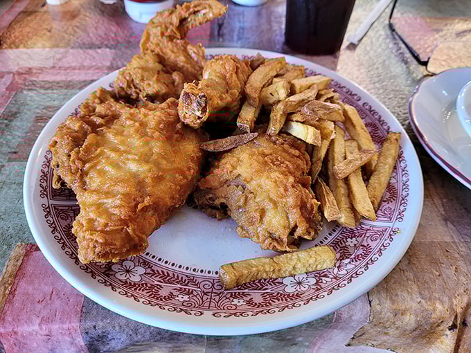 Fried chicken so golden and crispy, it practically demands a moment of silence before the first bite. Those fries aren't just sides—they're co-stars.