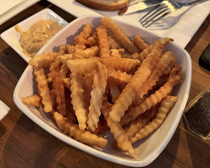 Crinkle-cut fries that walk the tightrope between crispy exterior and fluffy interior—the unsung heroes of any great tavern meal.